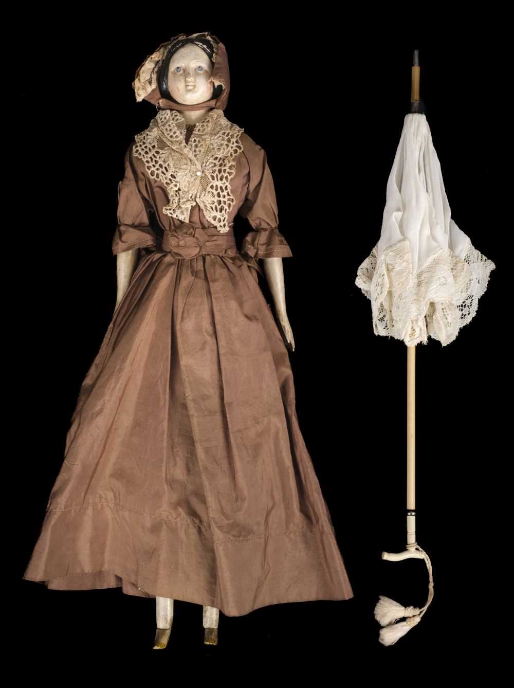 Lot 510 - Doll. A large wooden doll with parasol,